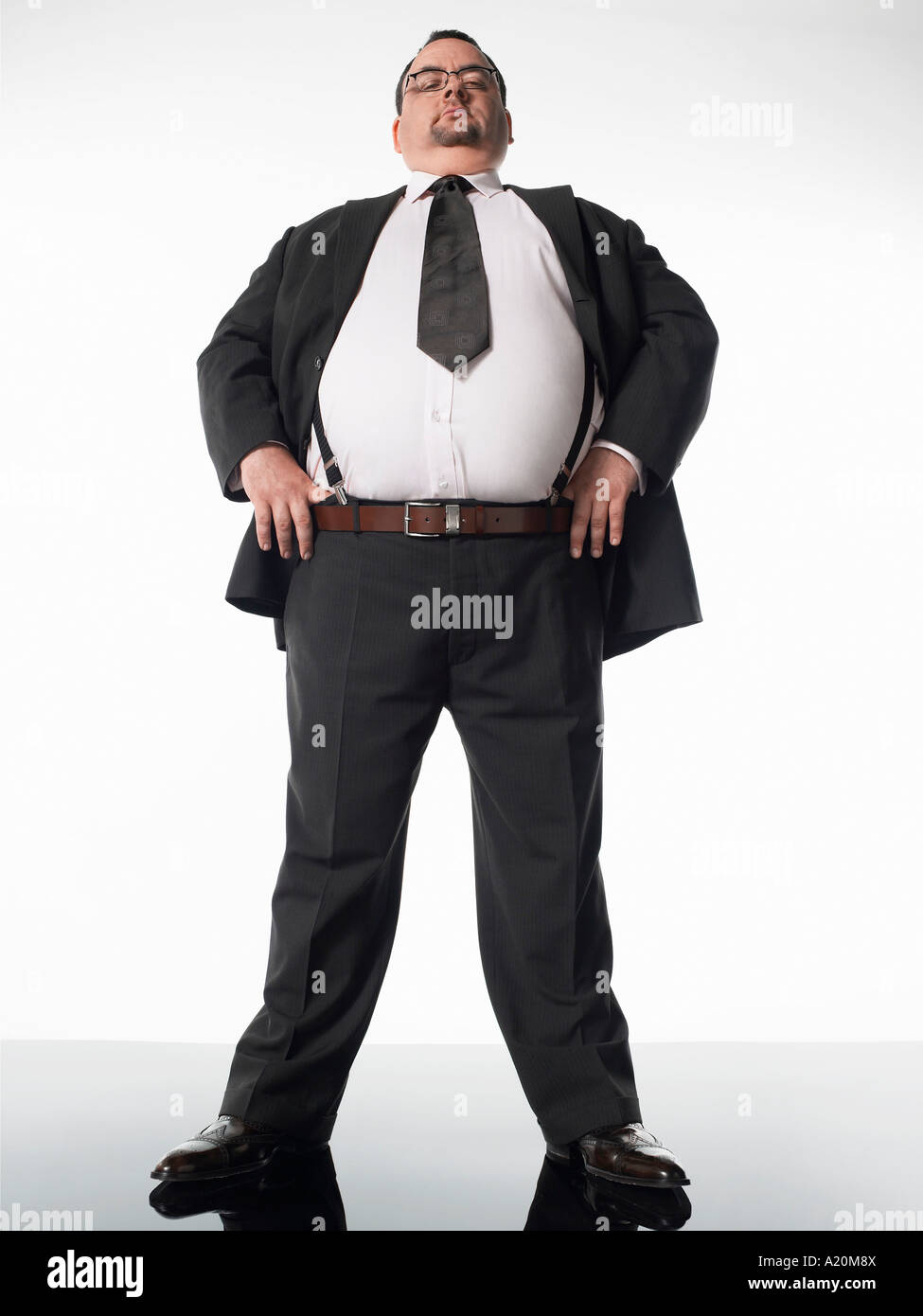Overweight businessman standing with thumbs in belt Stock Photo - Alamy