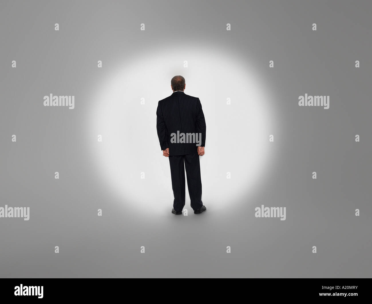 Businessman in spotlight, back view Stock Photo - Alamy
