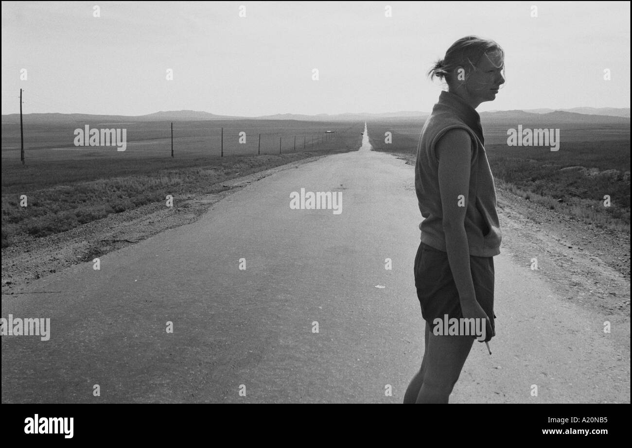 Tourist smoking a cigarette on the road in the steppes of Ovorkhangai ...