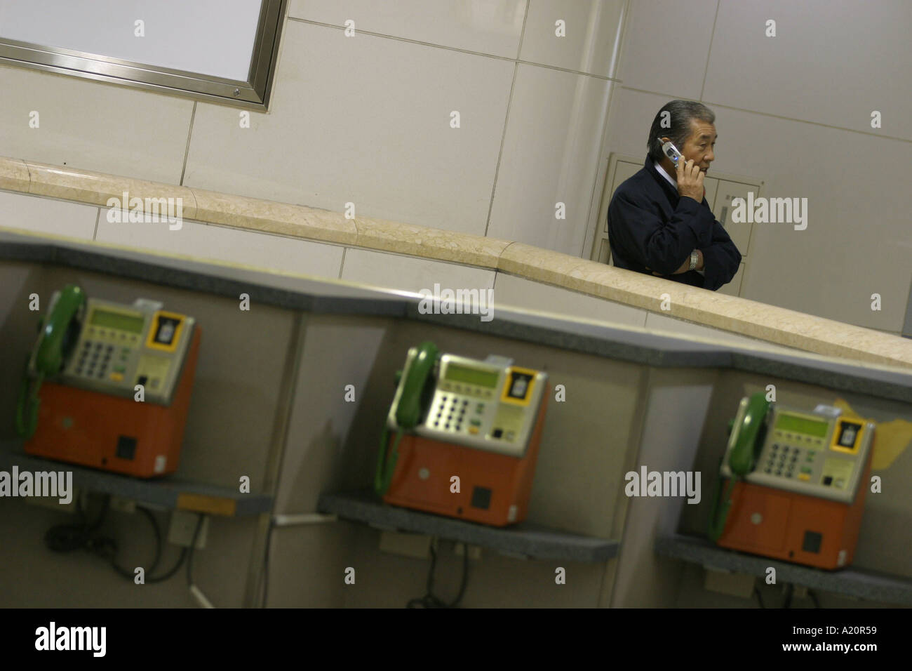 Japanese businessman, known as a salaryman, using his mobile telephone ...