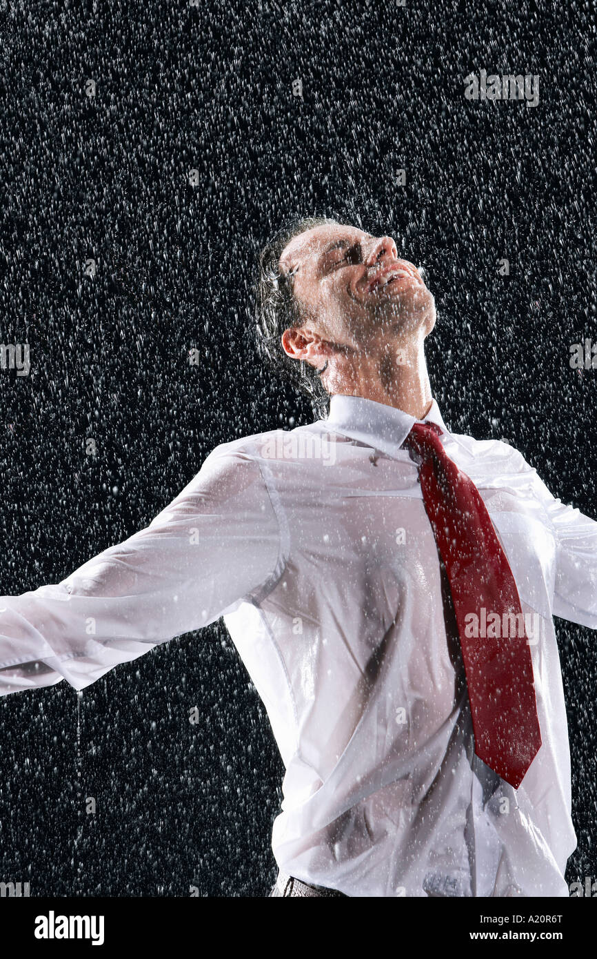 Businessman standing, arms spread facing incoming rain Stock Photo - Alamy