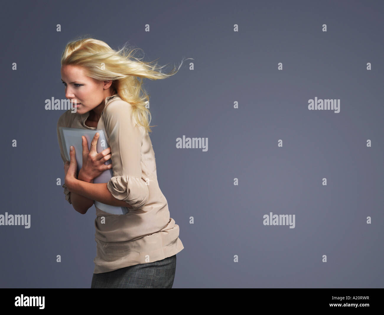 Woman with hair blowing, facing into wind, side view Stock Photo - Alamy