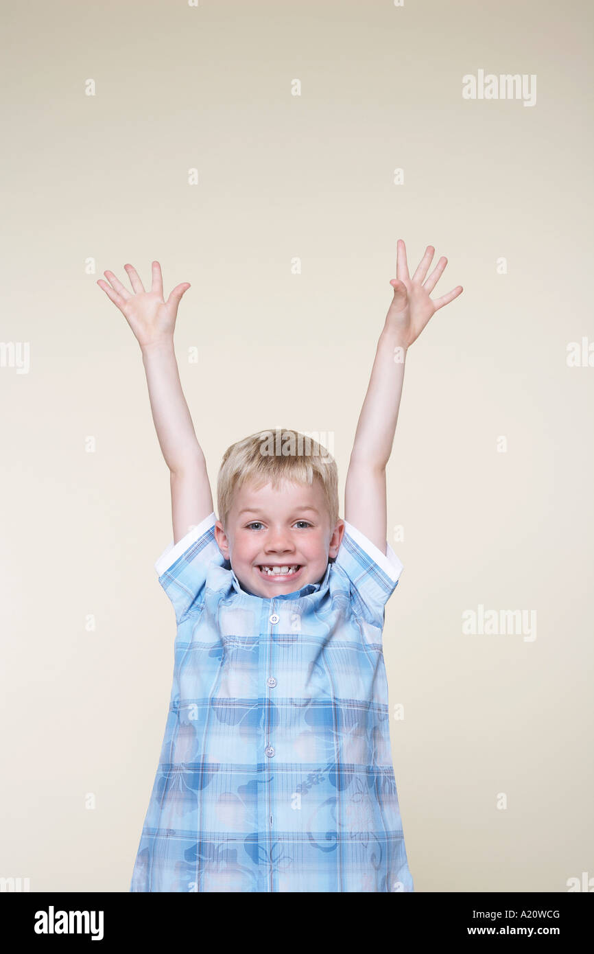 Smiling, excited boy standing with Arms Raised Stock Photo - Alamy