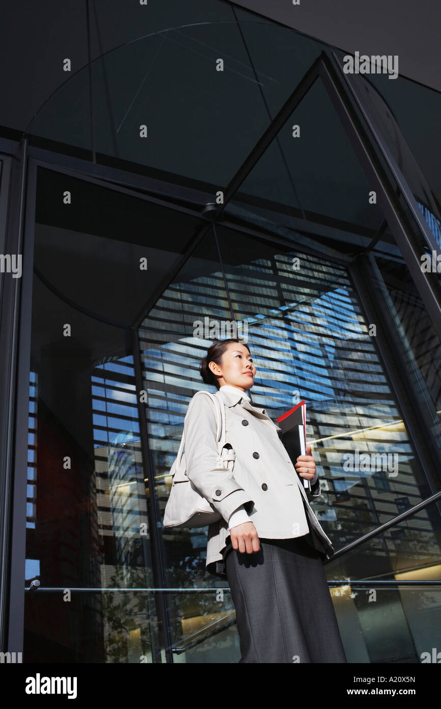 Woman Carrying Notebooks, standing outside, low angle view Stock Photo ...