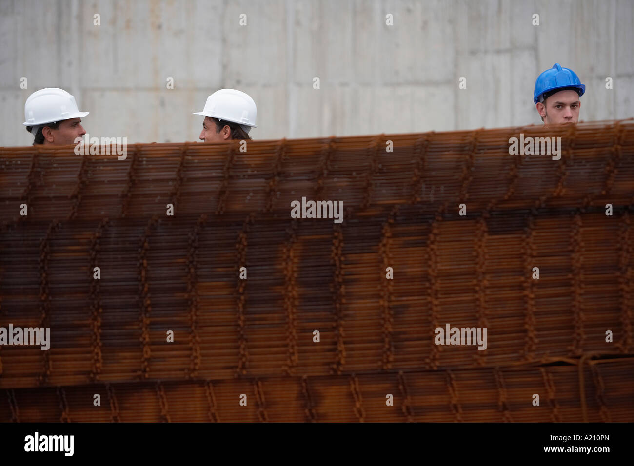 Construction workers behind a stack of rebar Stock Photo - Alamy