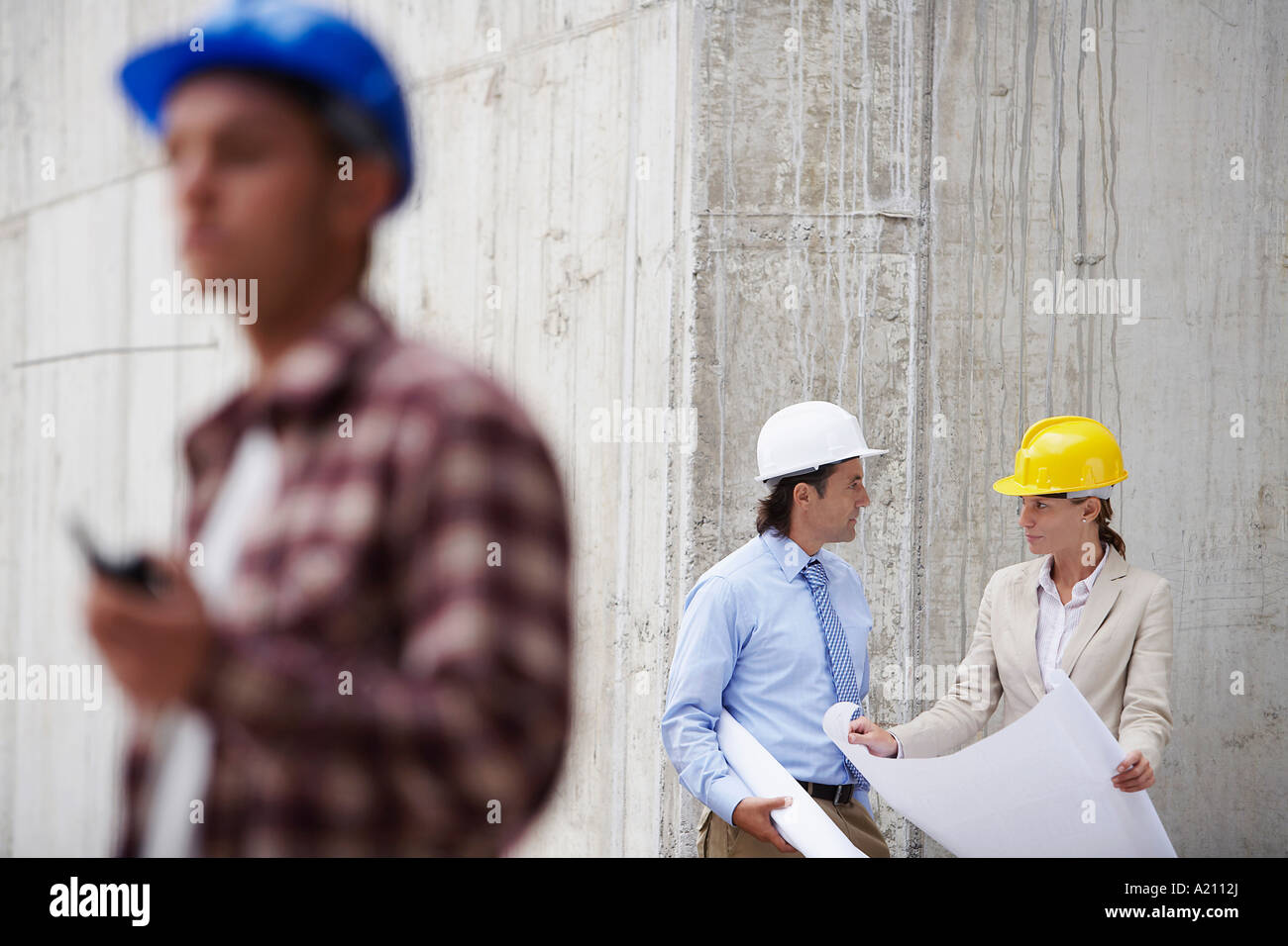 Managers and worker on construction site Stock Photo - Alamy