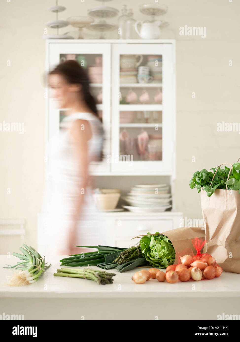 Woman walking behind Fresh Produce on Kitchen Counter, side view Stock ...