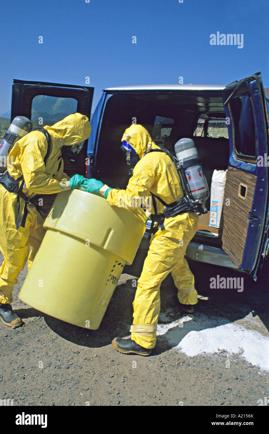 hazmat team places steel drum into plastic safety container Stock Photo ...