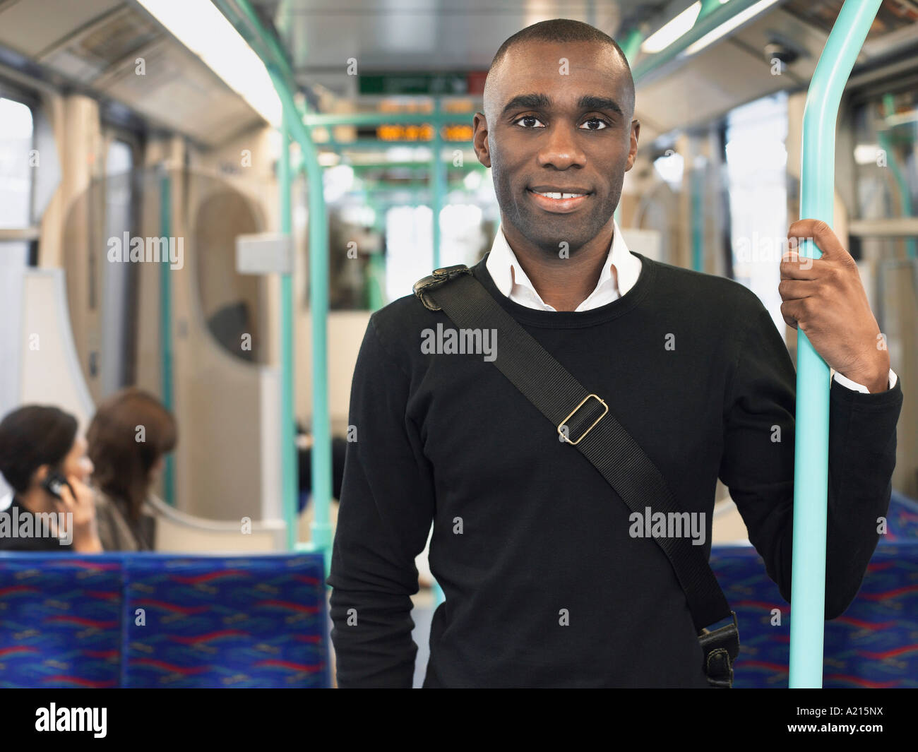 Smiling Commuter Standing on Train, holding bar Stock Photo - Alamy