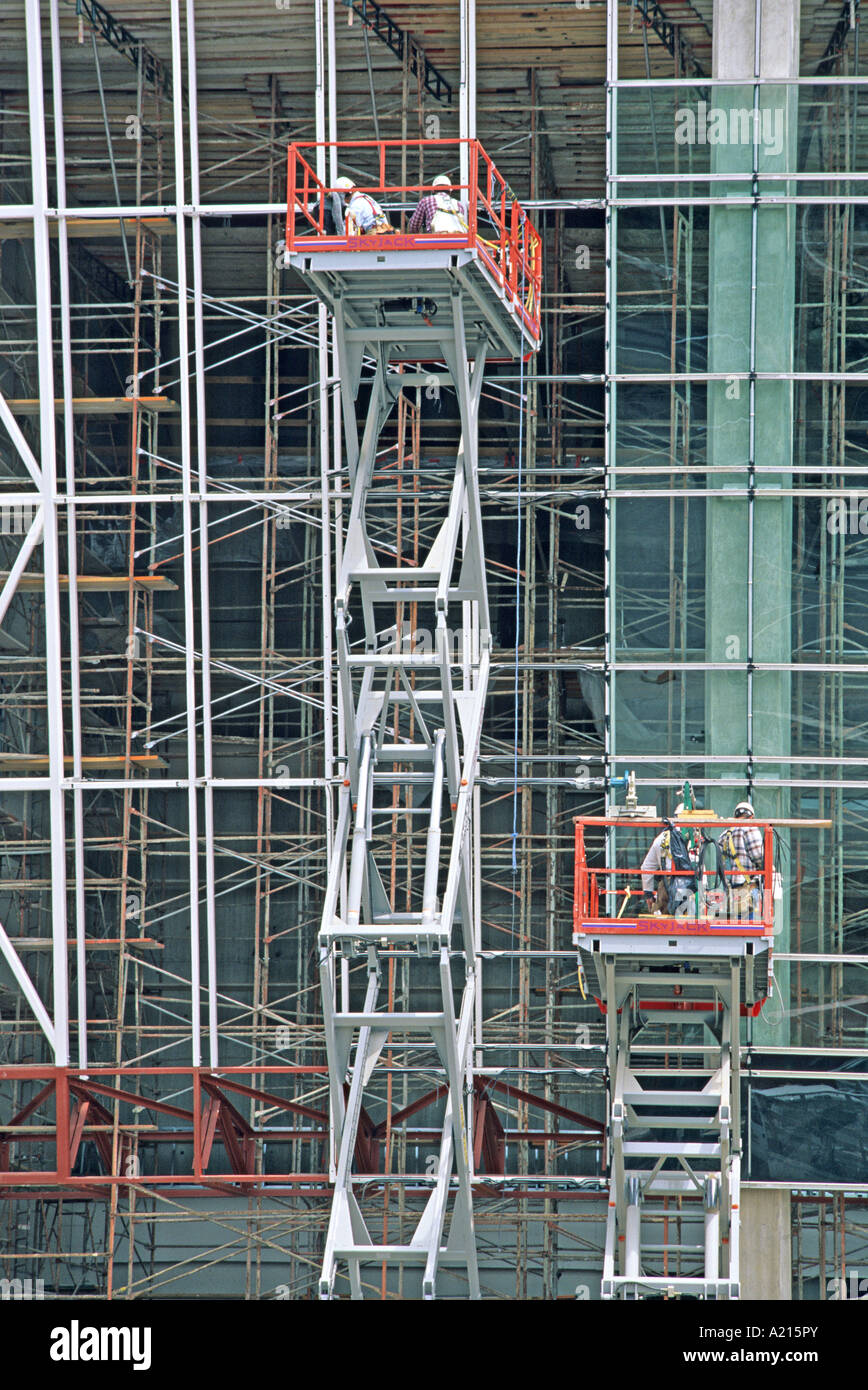 men working on scissors lifts at construction site Stock Photo - Alamy