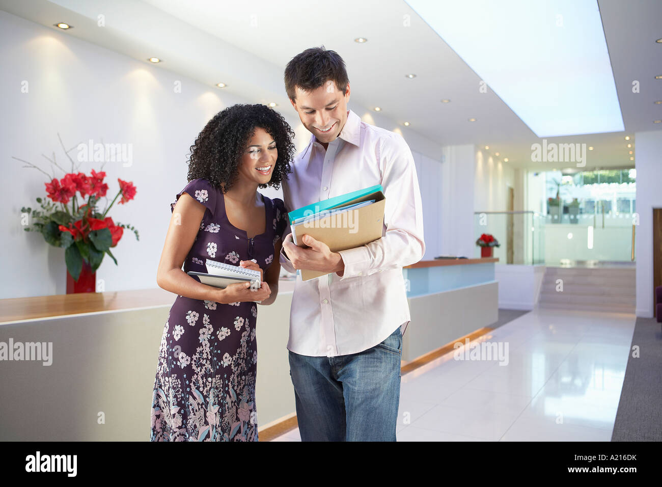 Casually dressed office workers standing, looking over paperwork Stock ...