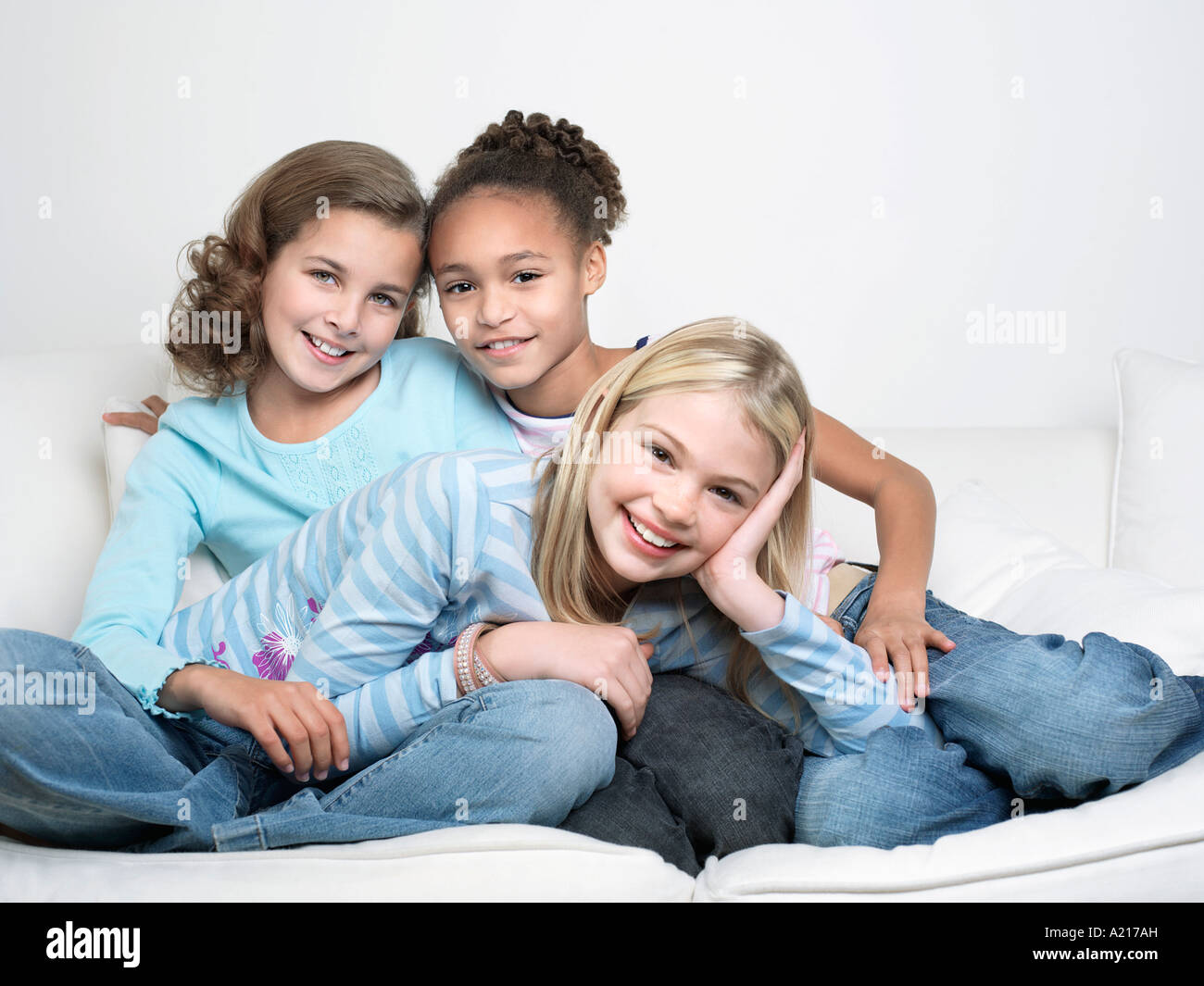 Young Friends sitting, leaning on one another, smiling Stock Photo - Alamy