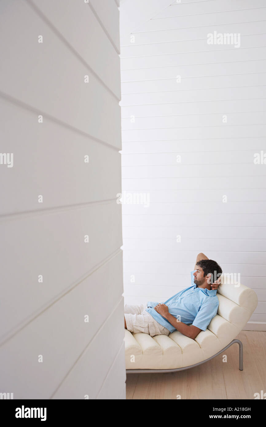 Man lying in reclining chair, half length Stock Photo - Alamy