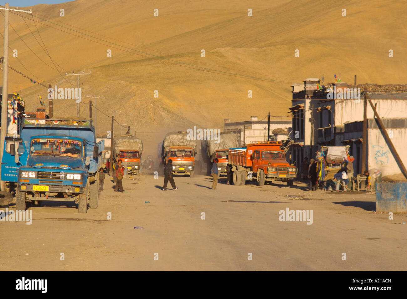 The main street in Tingri China and Chinese trucks passing through ...