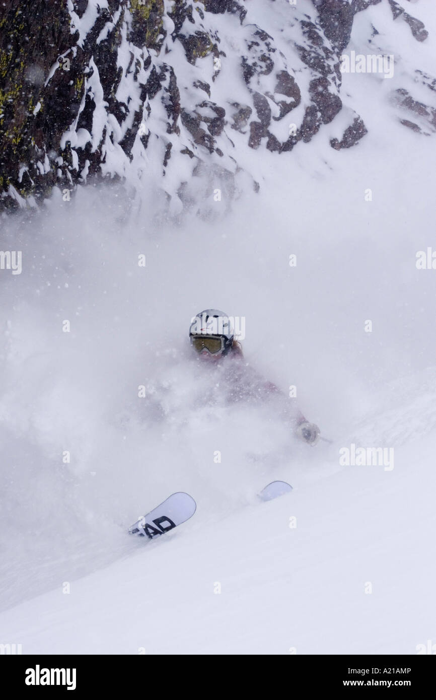 A woman skiing deep powder snow in a storm Alpine Meadows in Lake Tahoe ...