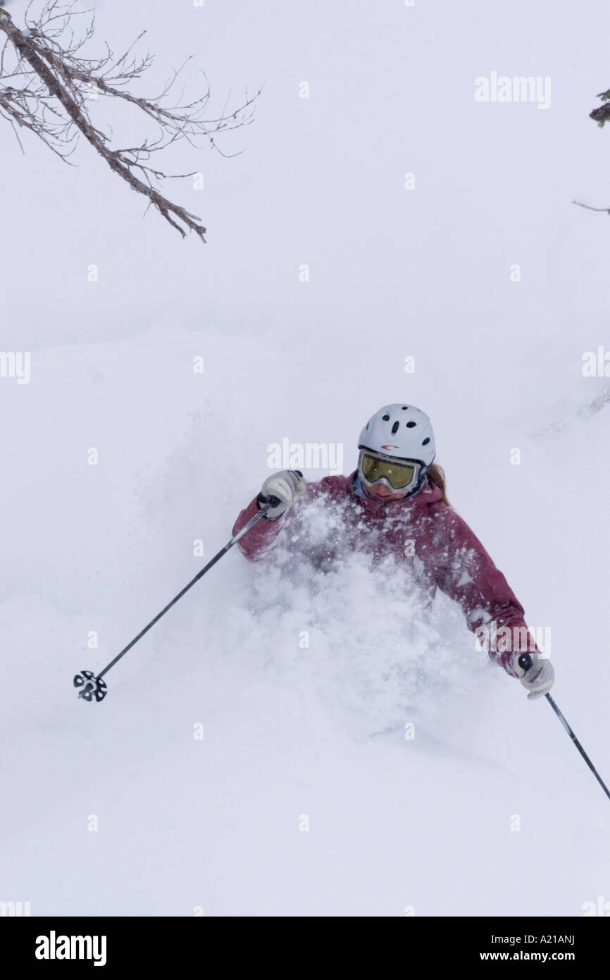 A woman skiing deep powder snow in a storm Alpine Meadows in Lake Tahoe ...