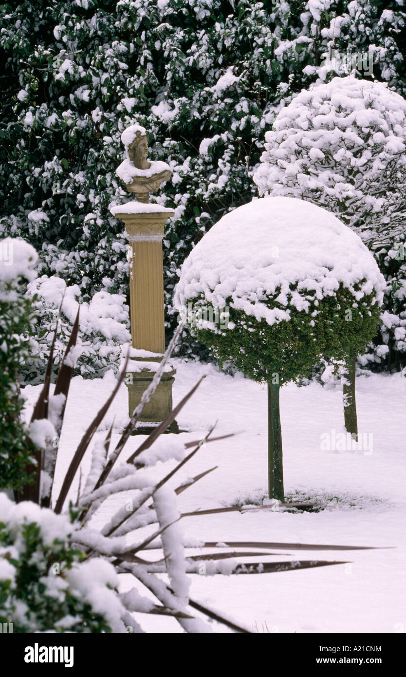 Sculpture with clipped topiary trees in snowy winter garden Stock Photo ...