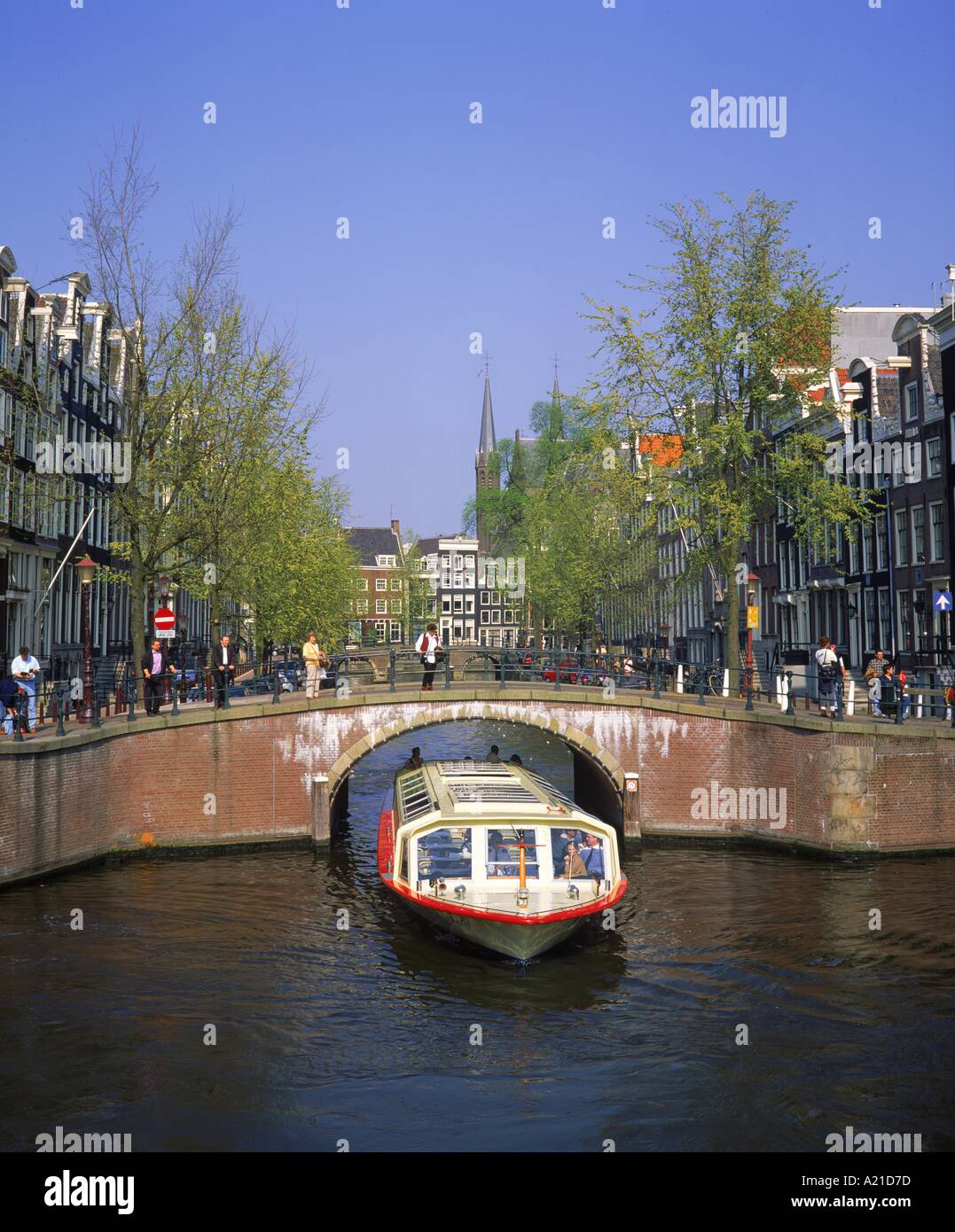 Tourist boat passes under a bridge on the Keizersgracht in Amsterdam ...