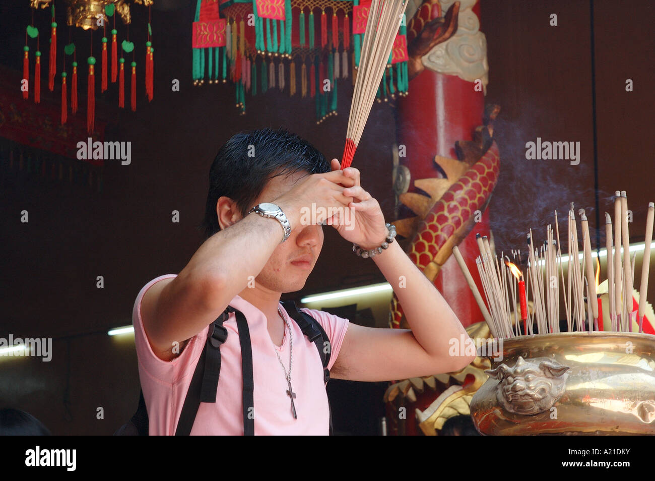 Chinese man praying with jossticks Stock Photo - Alamy