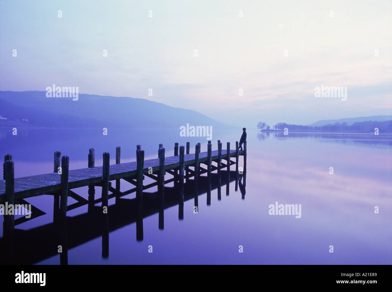 Person at the end of a jetty in Coniston Water the Lake District ...