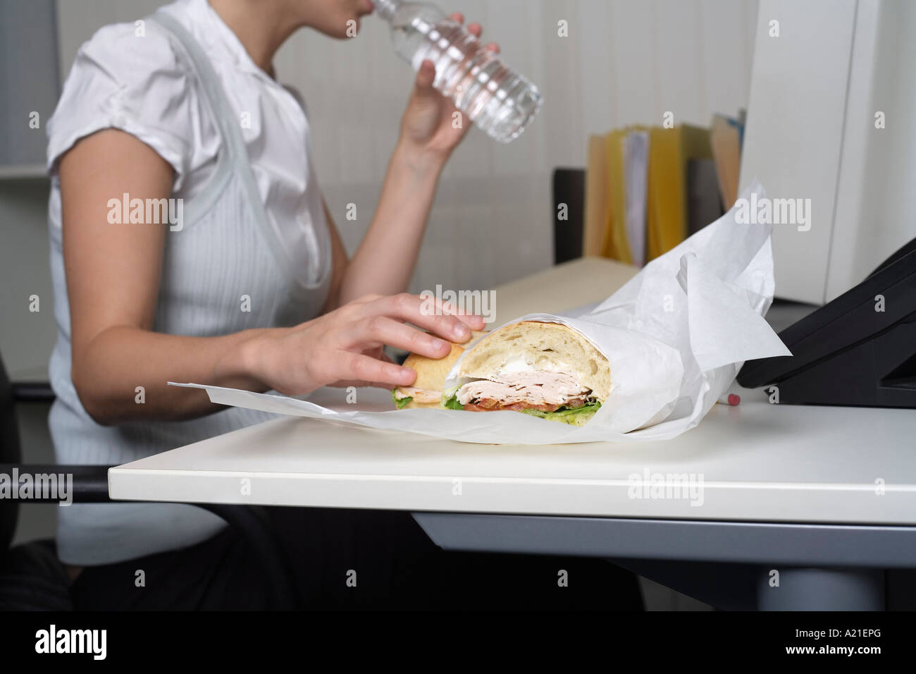 Businesswoman Eating at Desk Stock Photo - Alamy