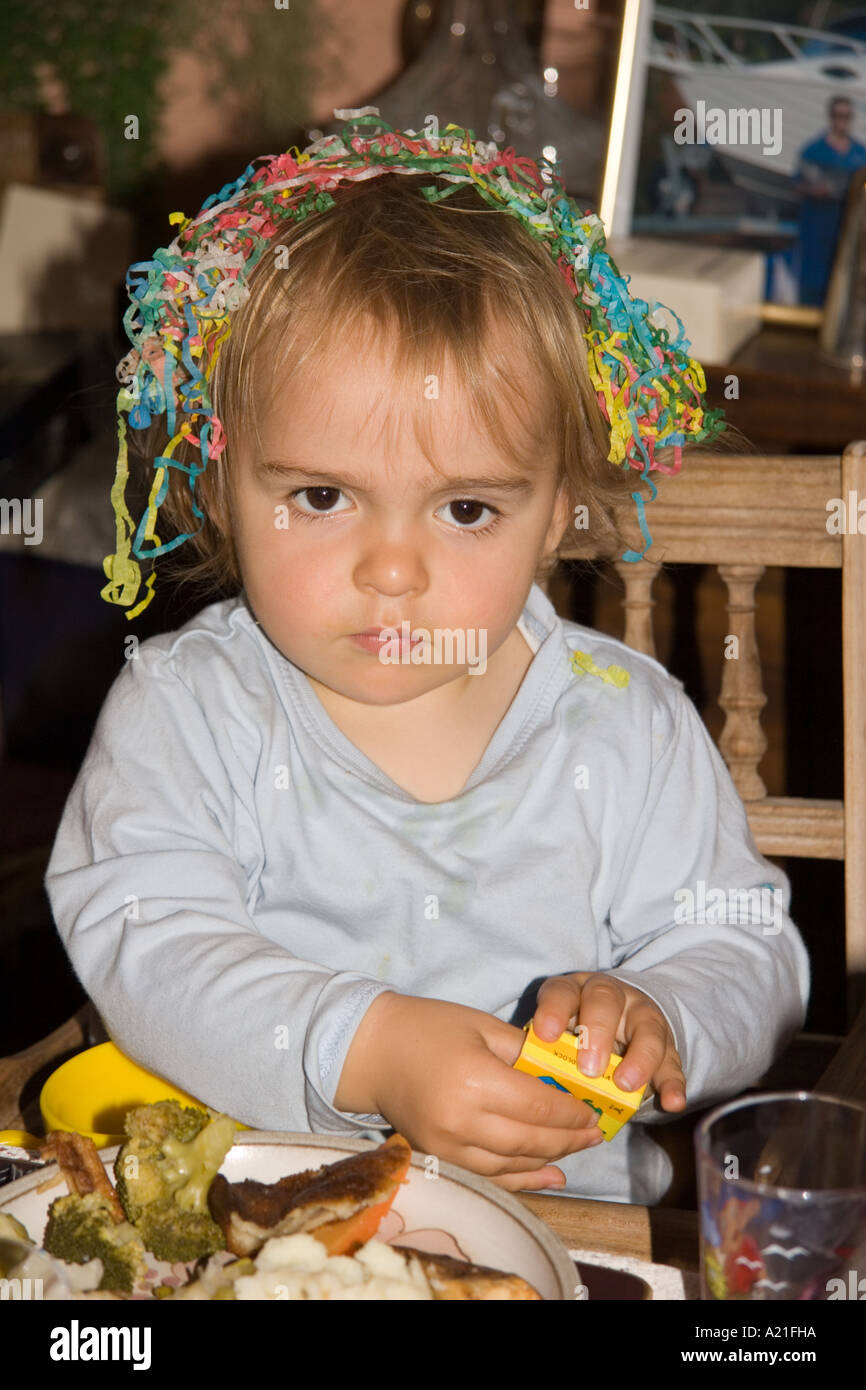 A young boy looks unhappy at christmas child infant boys streamers ...