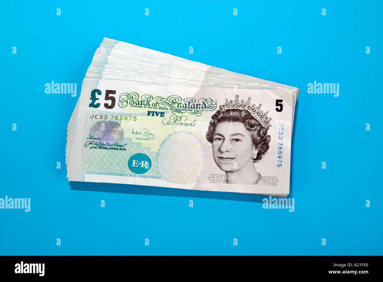 Pile of British five 5 pound bank notes on blue Stock Photo - Alamy