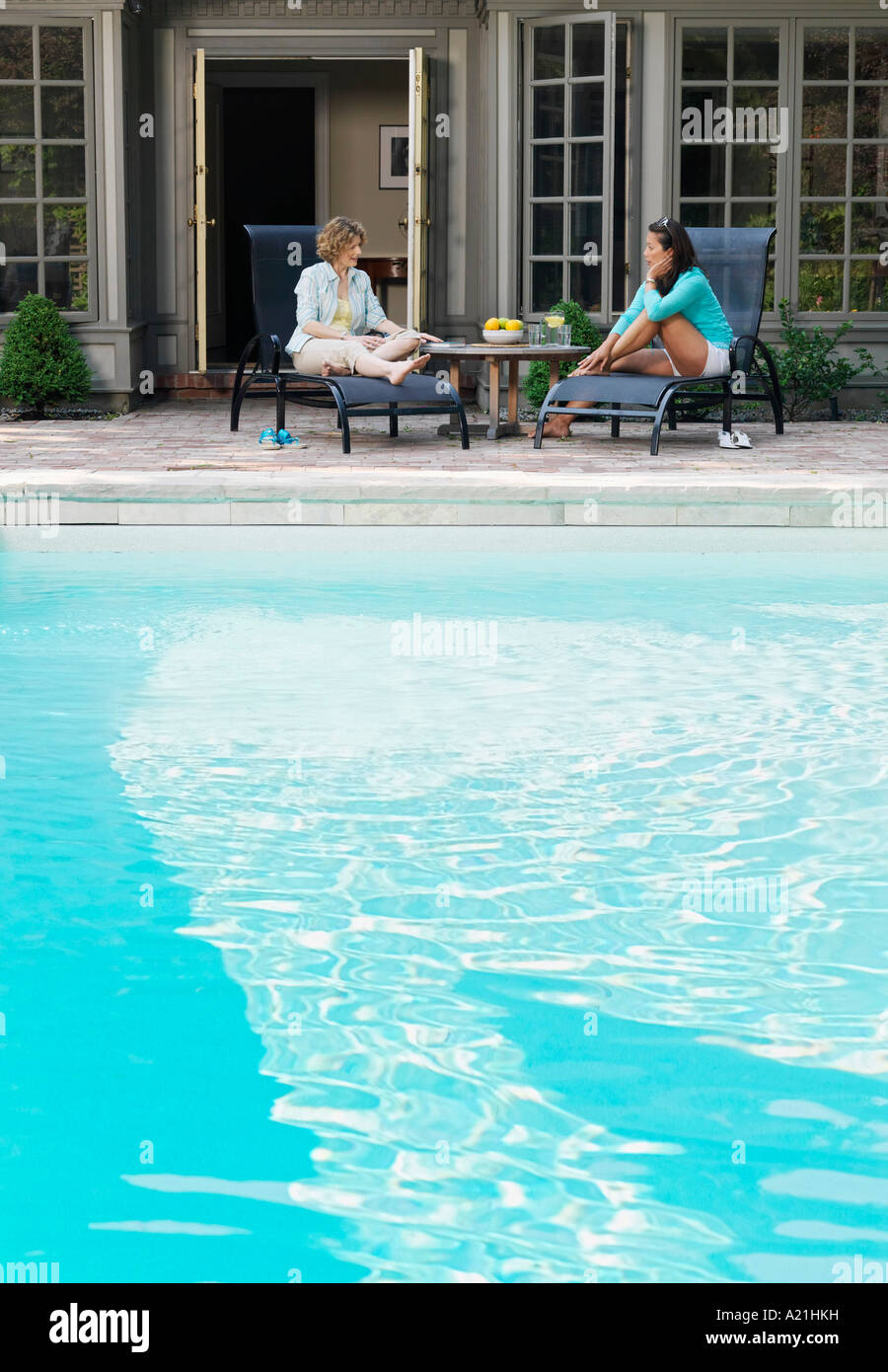 Two women lounging poolside hi-res stock photography and images - Alamy