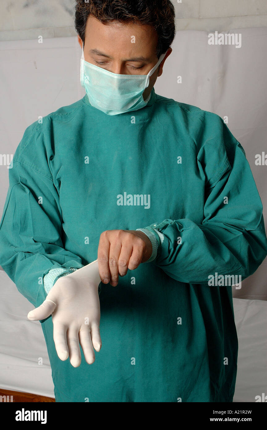 Young Indian Doctor surgeon with face mask in green operation theatre ...