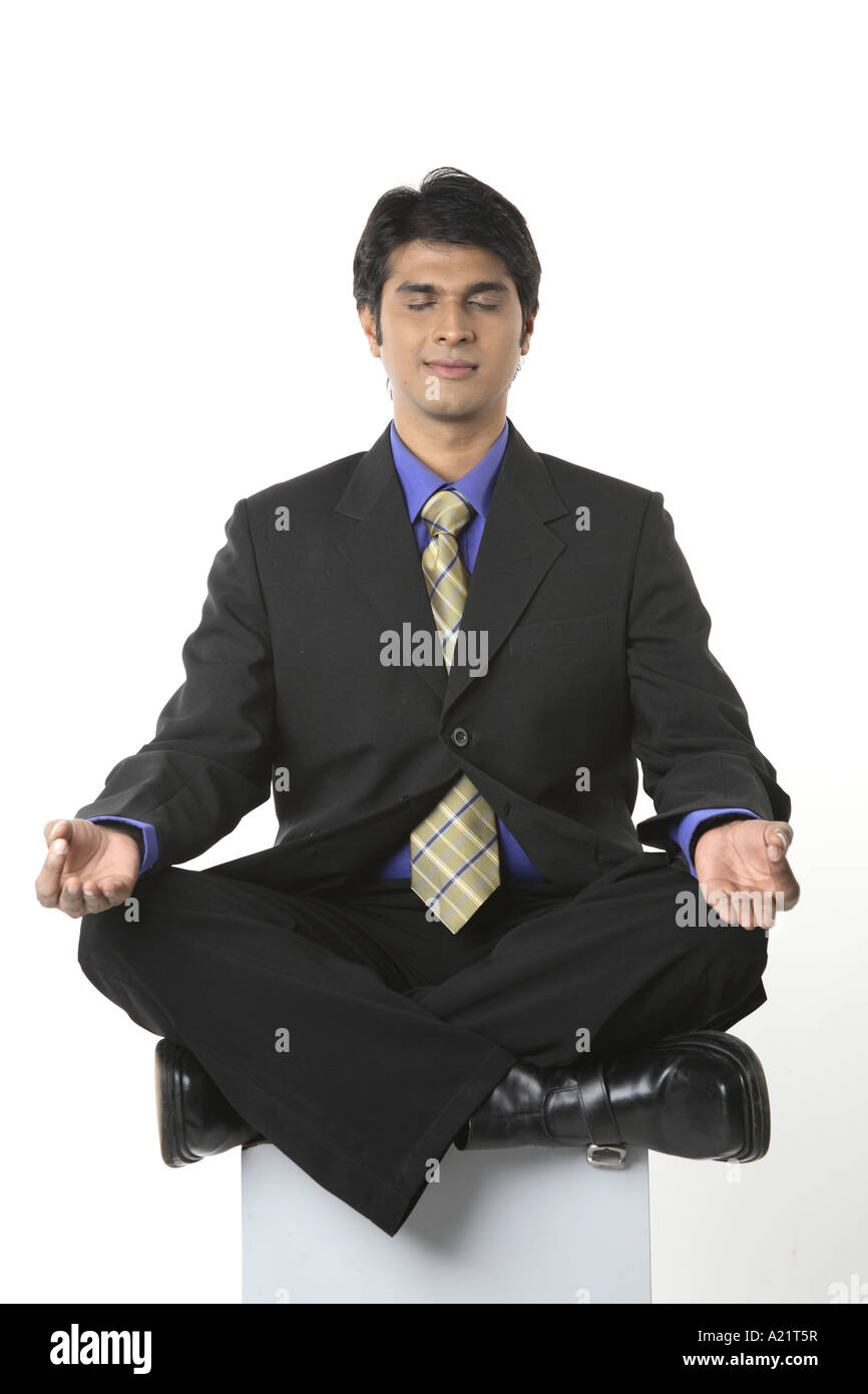 Executive sitting in yoga posture Stock Photo - Alamy
