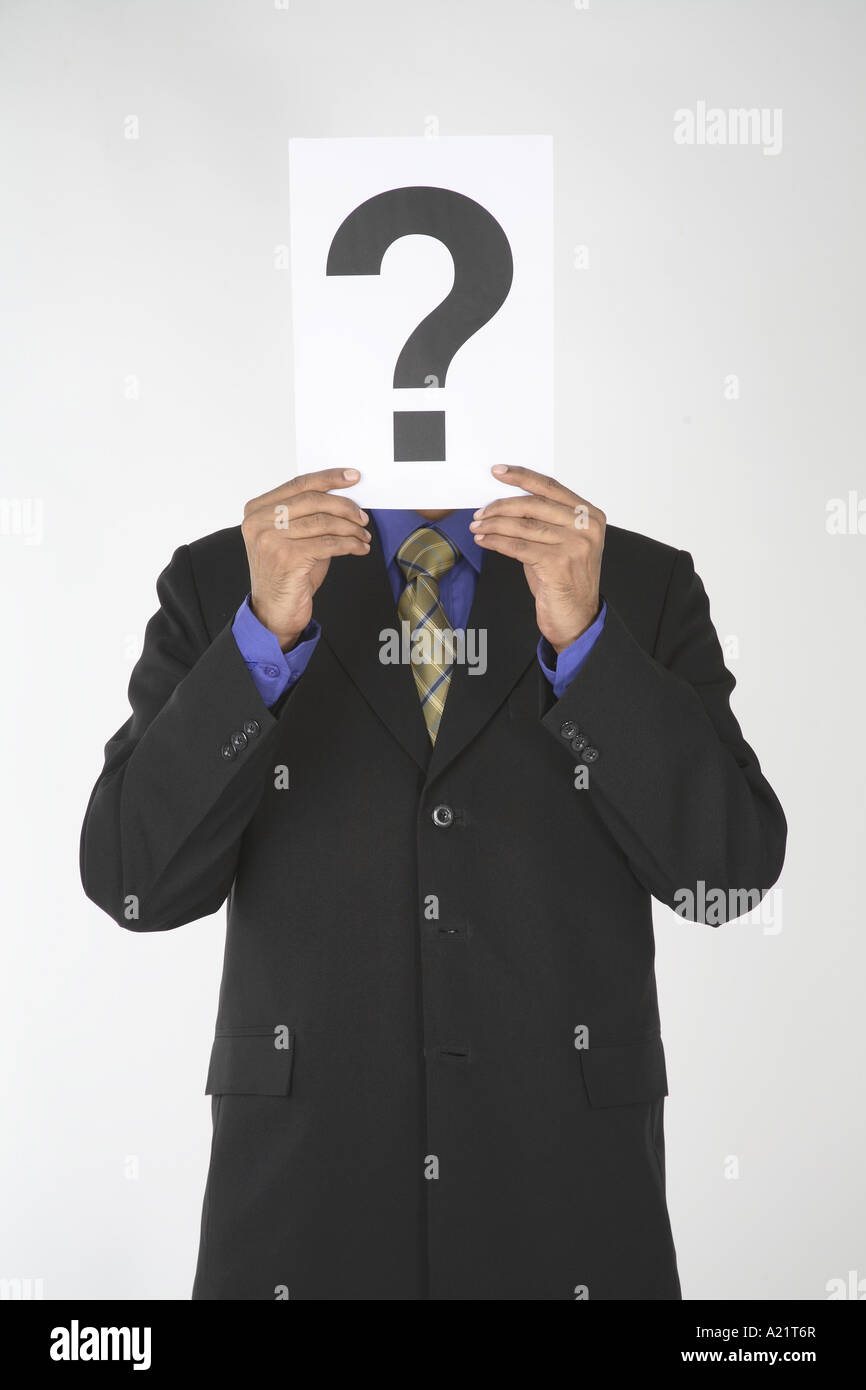 Executive holding paper question mark in front of his face Stock Photo ...