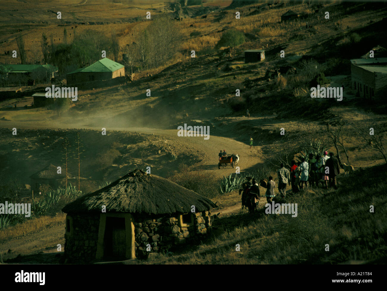 A group of people at the roadside with a thatched roofed rondavel ...