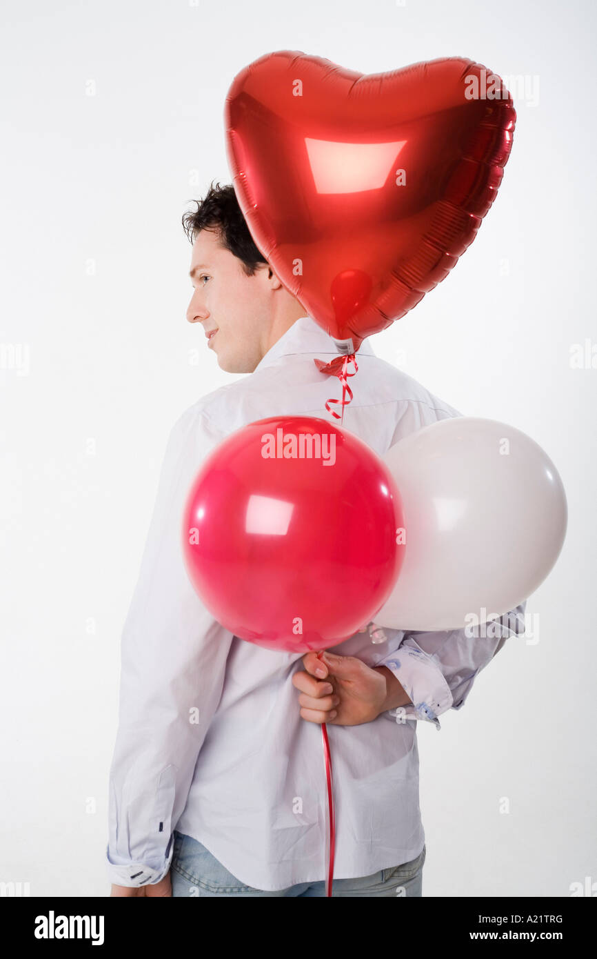 Man Holding Balloons behind Back Stock Photo - Alamy