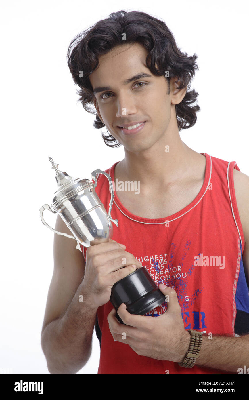 ANG200544 Teenage boy winning trophy cup holding trophy in both hands ...