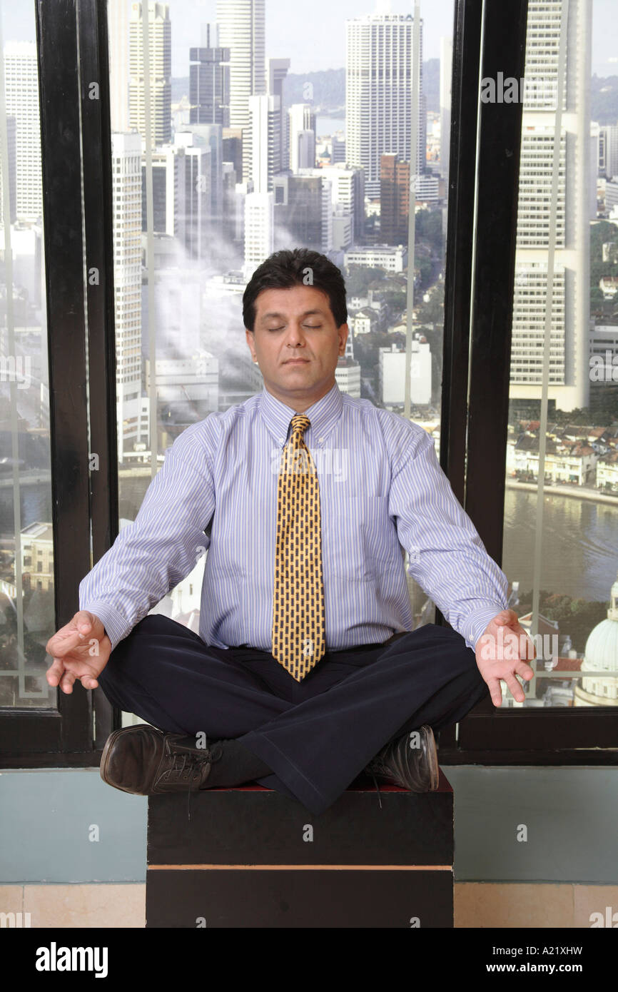 Boss in office doing Yoga meditation peace Stock Photo - Alamy
