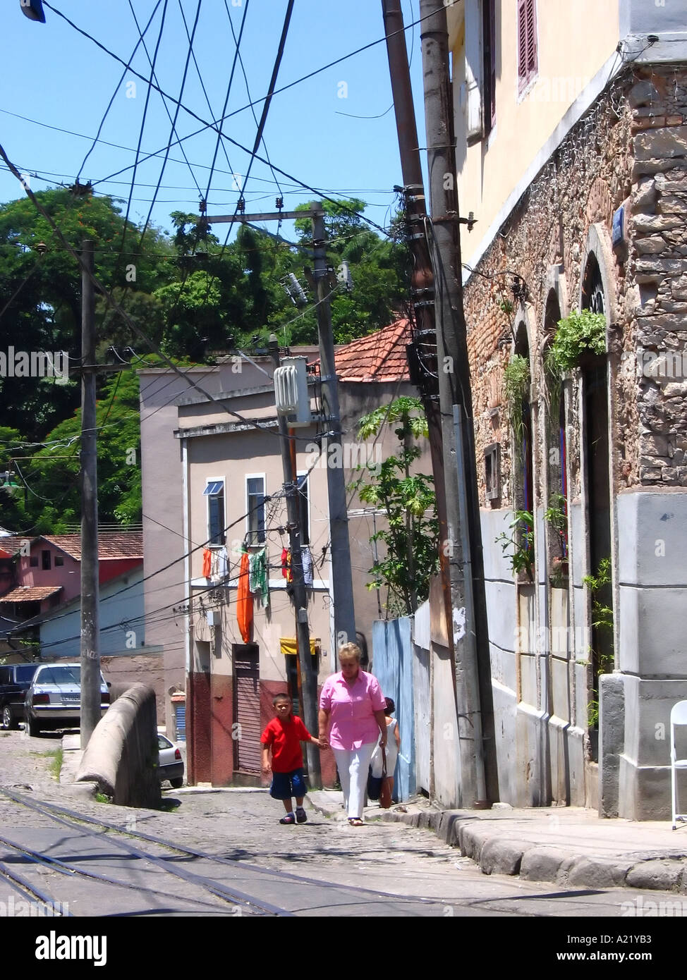 mother and child walk up street with tram lines, Santa Teresa, Rio de ...
