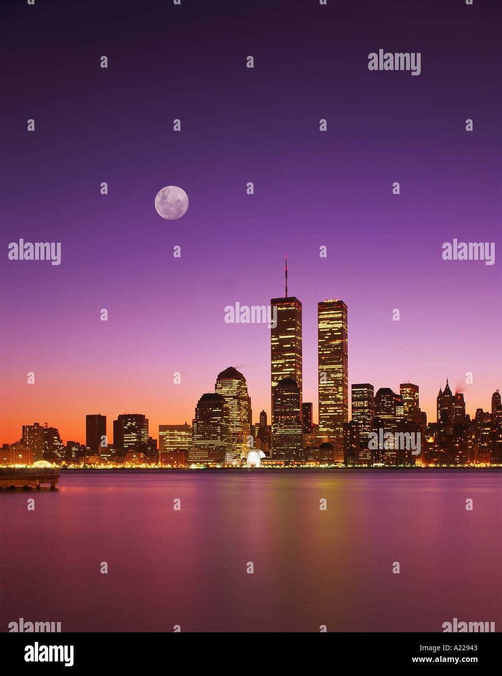 The city skyline illuminated in the evening with the moon above New ...