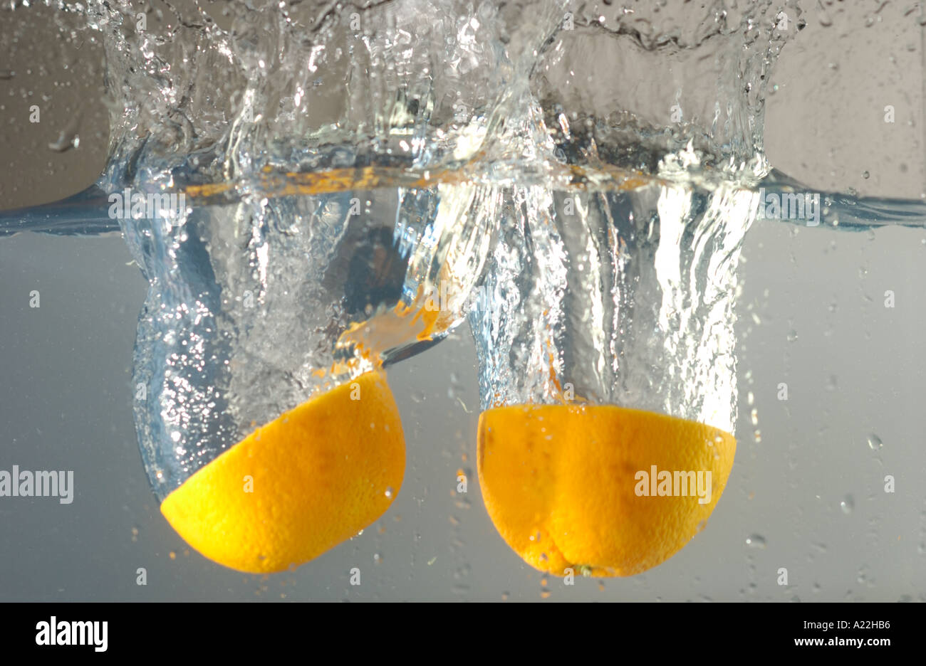 orange fruit dropped into water making splash Stock Photo - Alamy