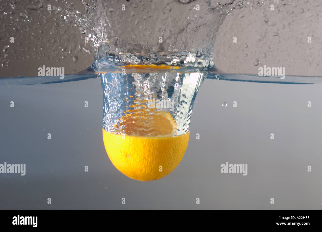 orange fruit dropped into water making splash Stock Photo - Alamy