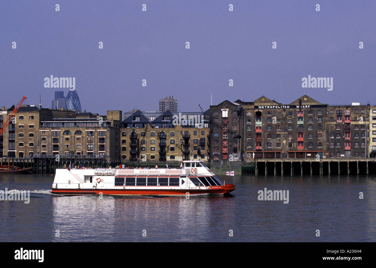 Tourist sightseeing boat on the River Thames sailing through Docklands ...