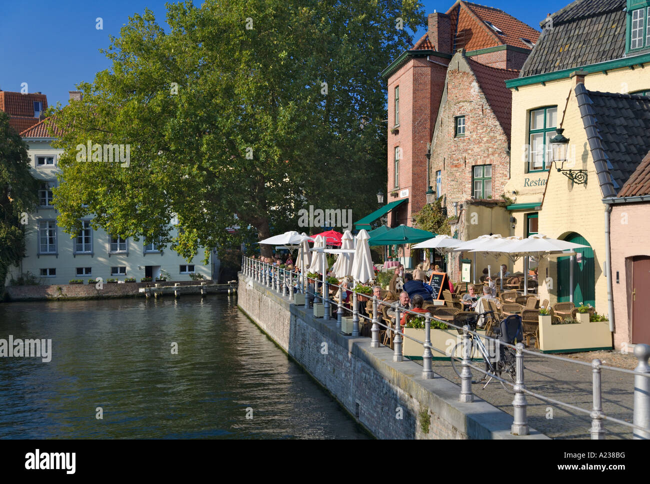 Terrace seating at a canal side restaurant Langestraat Bruges Belgium ...