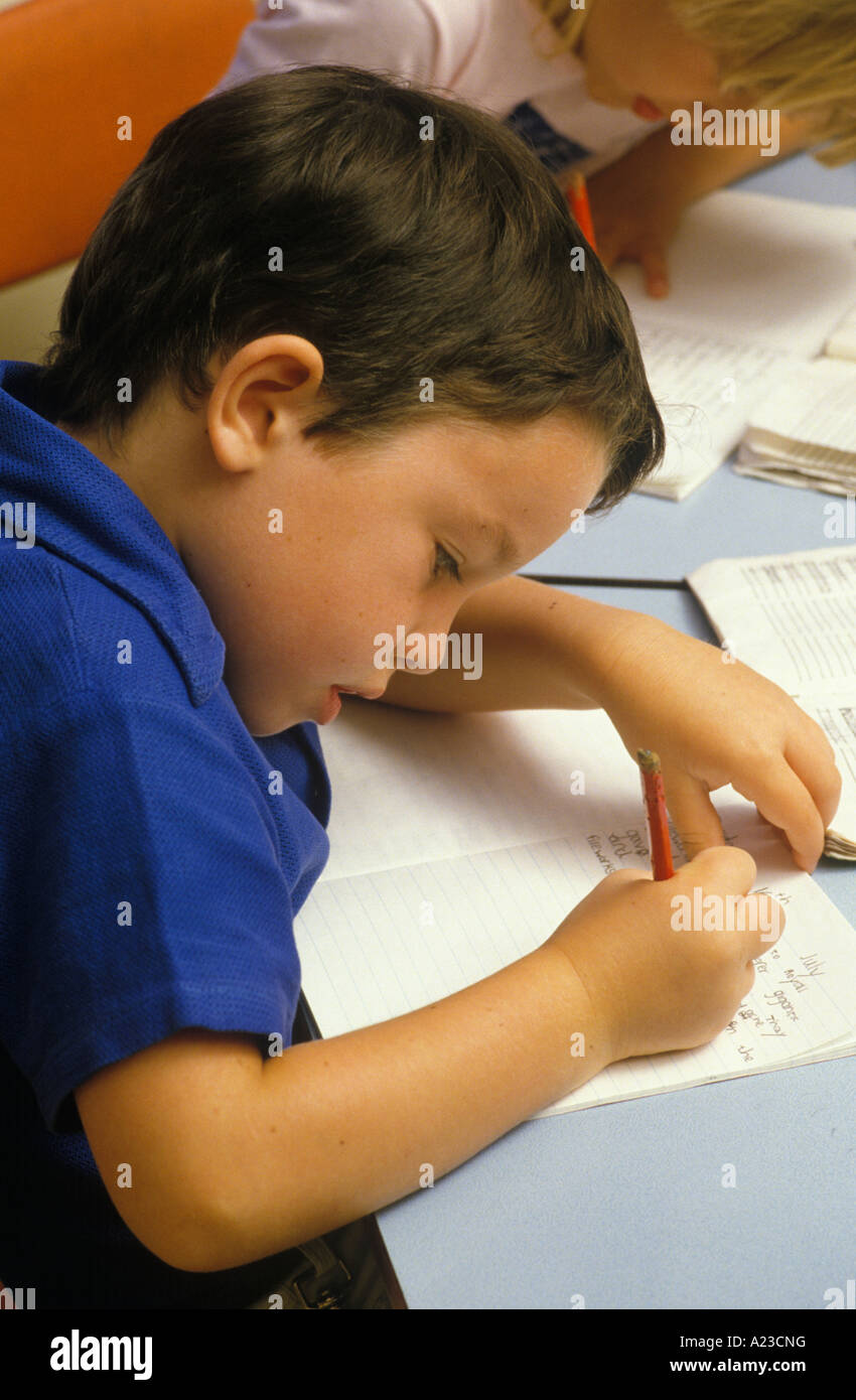 young boy in primary school class writing Stock Photo - Alamy