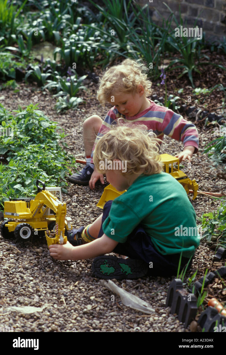 boys playing with model diggers in garden Stock Photo - Alamy