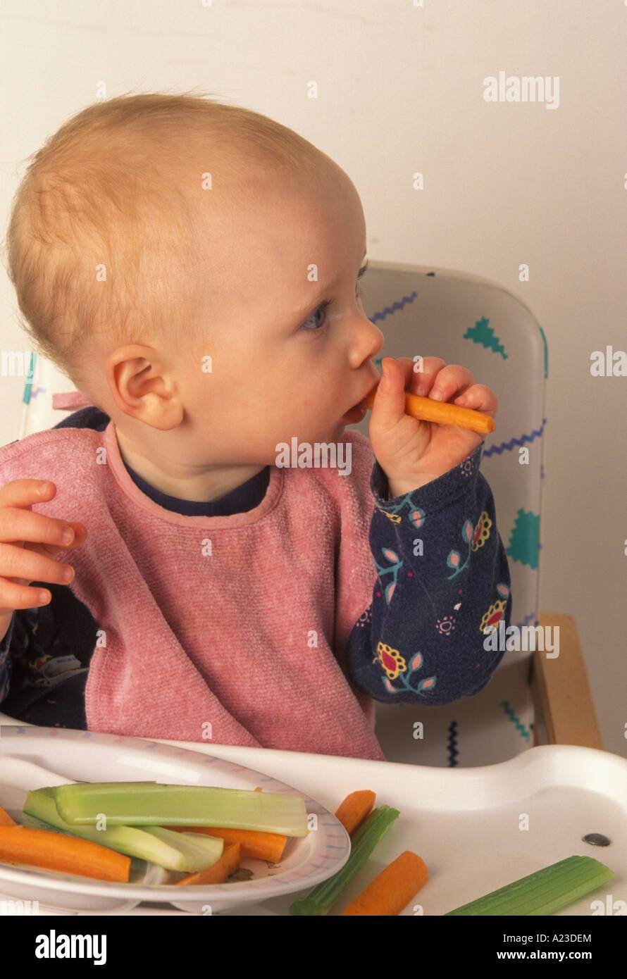 baby eating finger foods in her high chair Stock Photo - Alamy