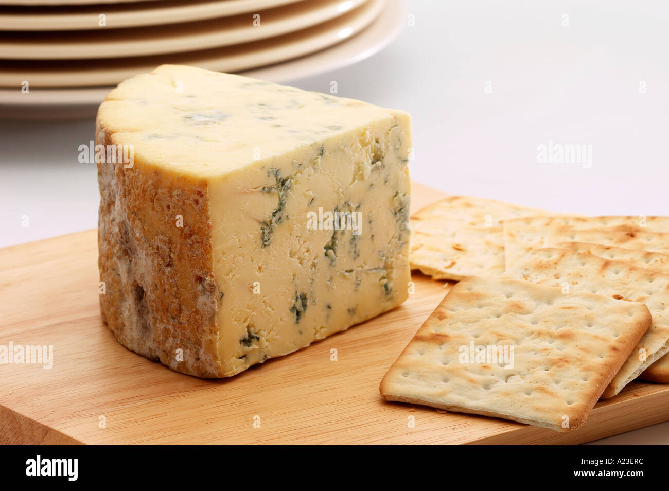 Wedge of stilton with three cream cracker biscuits on board Stock Photo ...