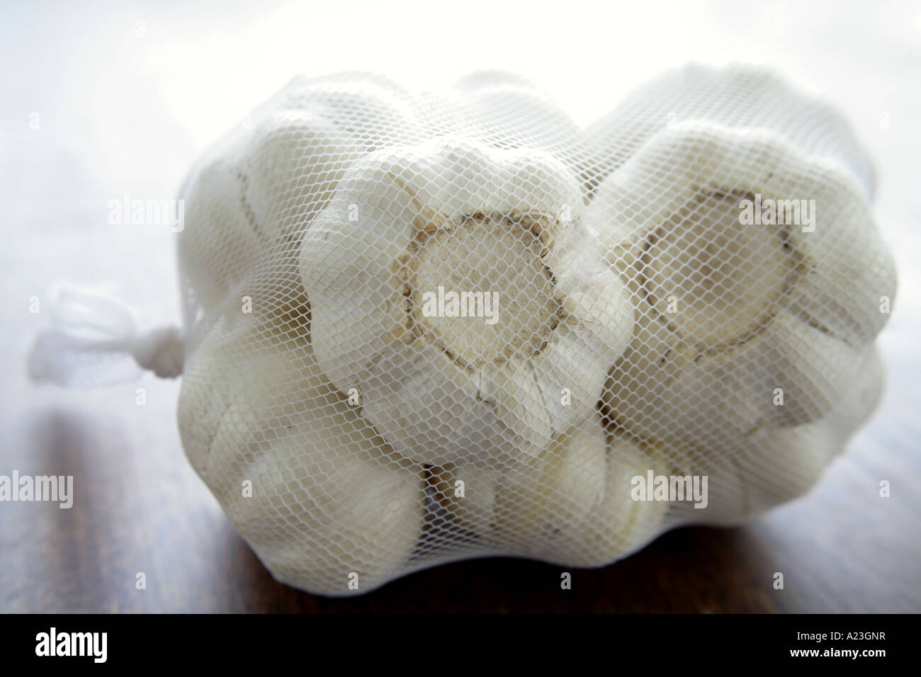 Garlic in net bag Stock Photo - Alamy