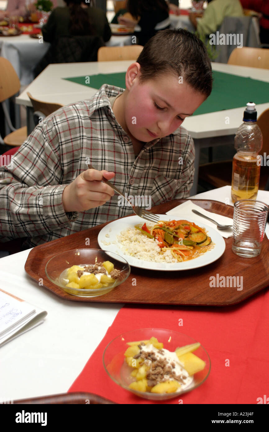 boy eating dinner lunch at school canteen Stock Photo - Alamy