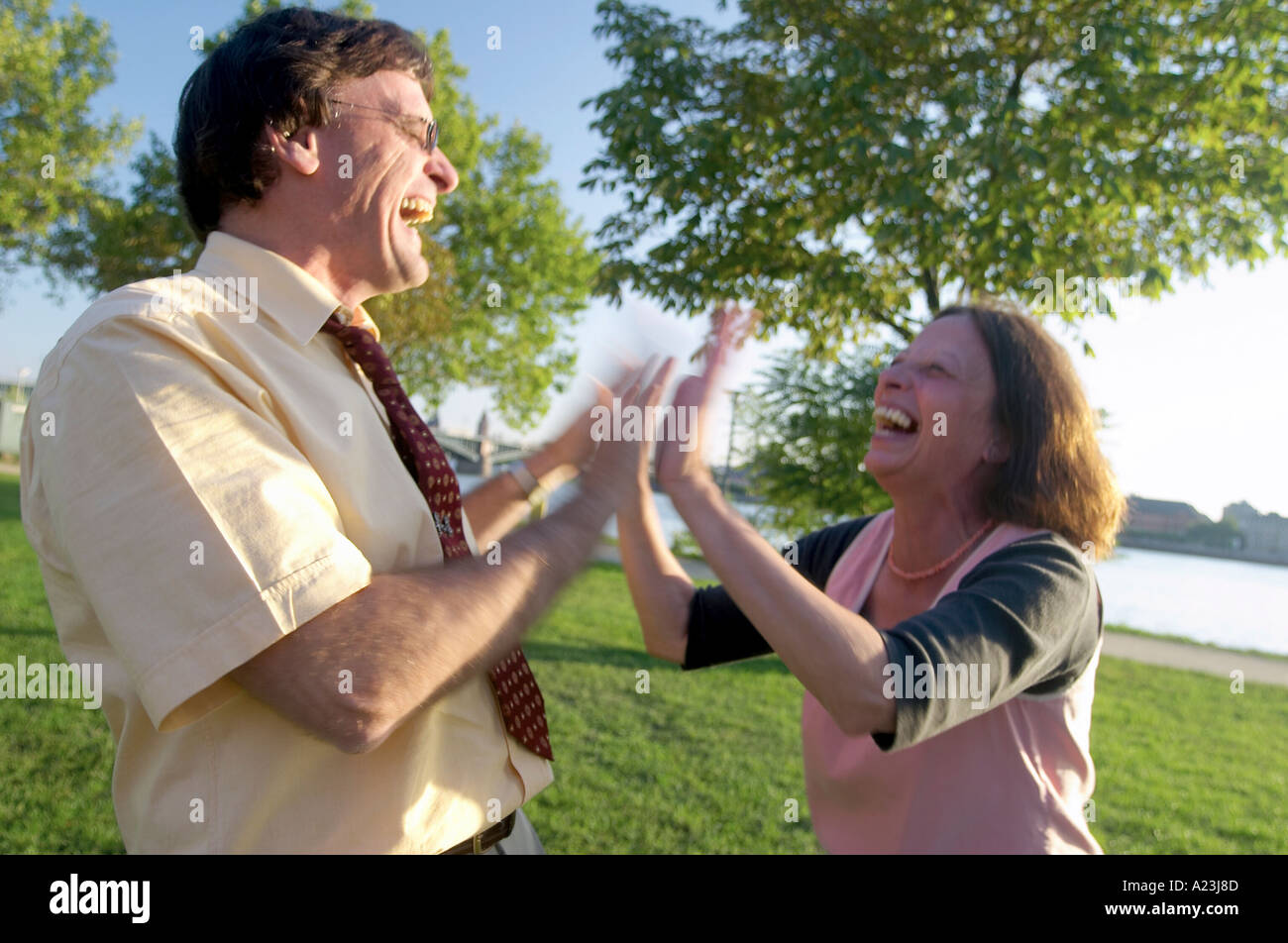 Man and Woman laughing and clapping hands together Stock Photo - Alamy
