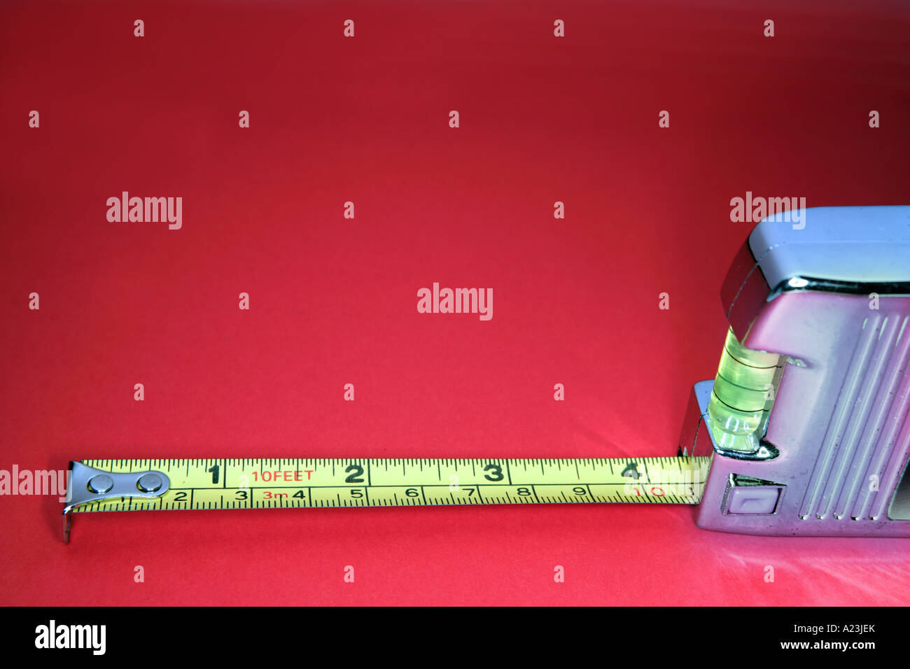 Tape measure with built-in spirit level on red Stock Photo - Alamy