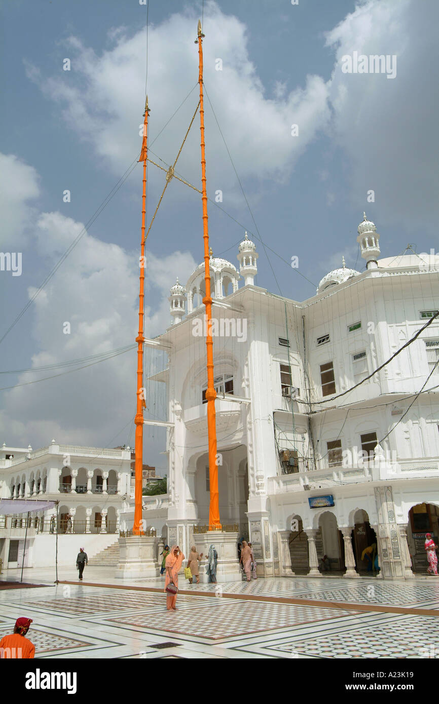 Woman standing in front of twin flags of Akal Takht Golden Temple Stock ...